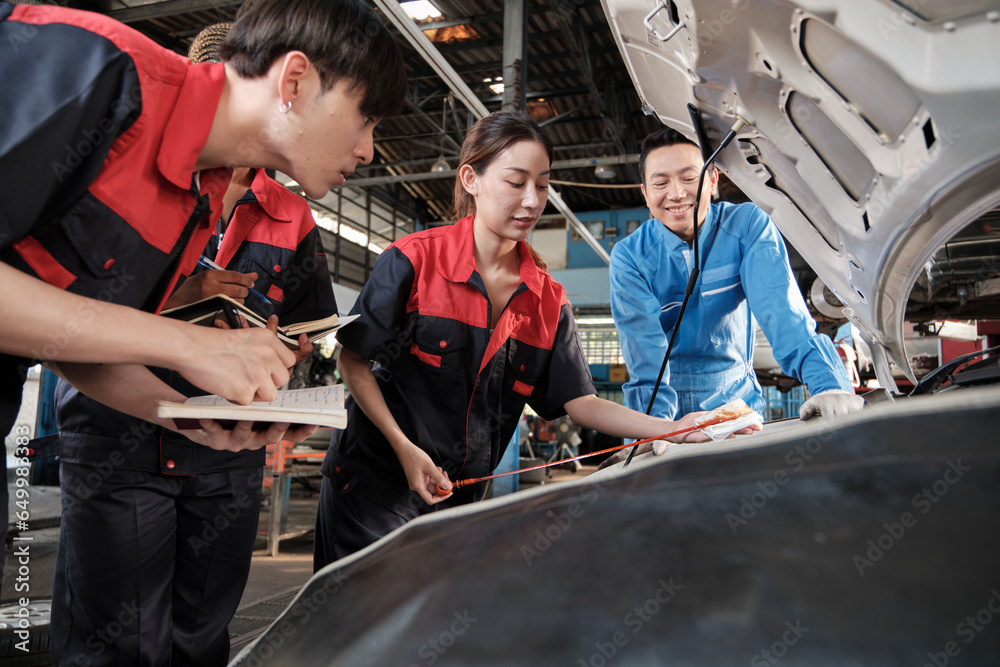 Asian male professional automotive supervisor advises and inspects a ...