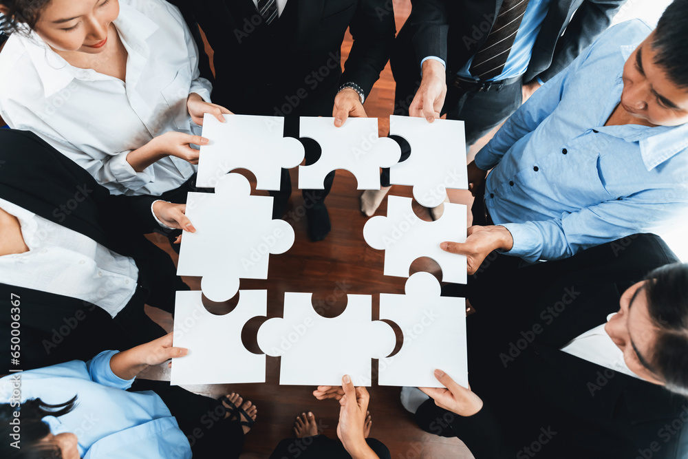 Top view multiethnic business people holding jigsaw pieces and merge ...