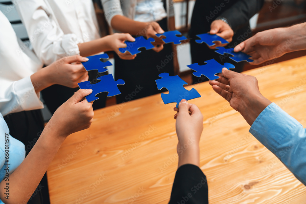 Multiethnic business people holding jigsaw pieces and merge them ...
