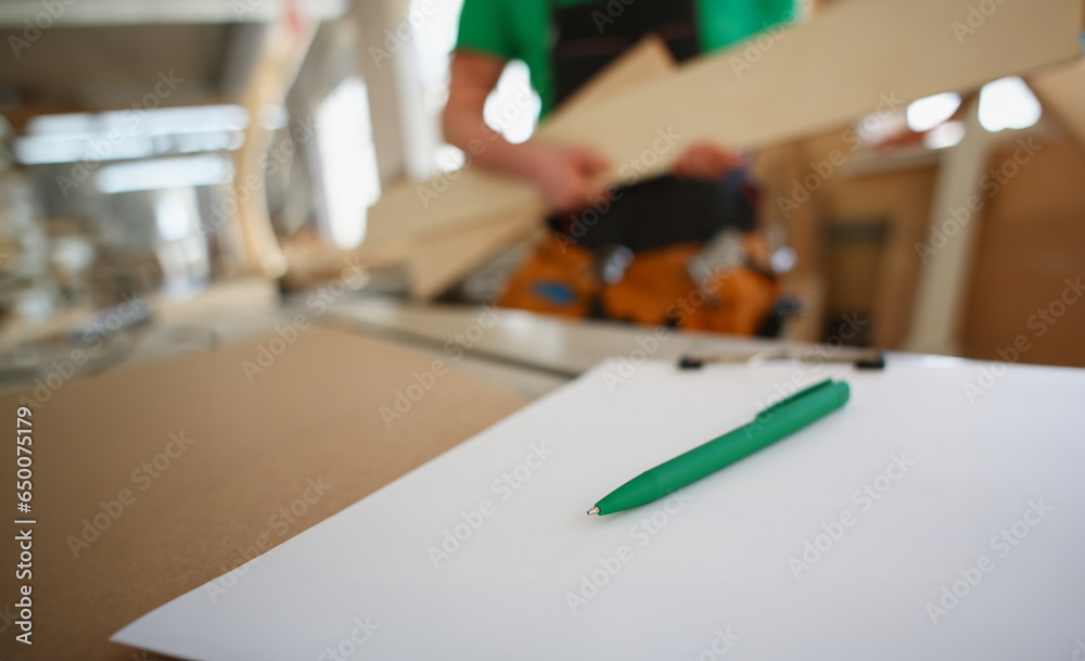 Drafting green pen lying on desk on clipboard pad closeup. Manual job ...