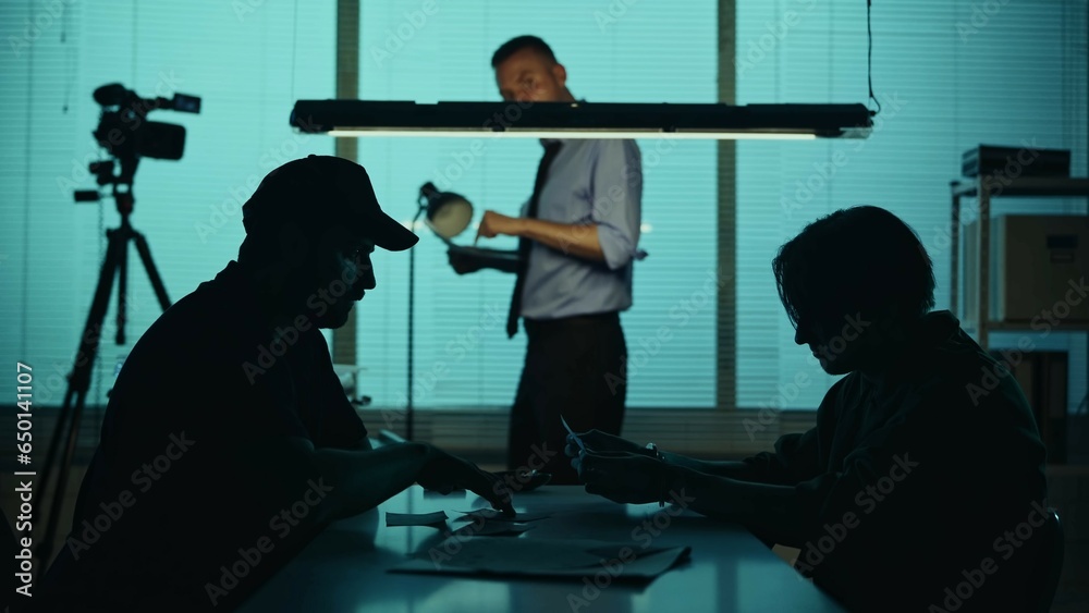 Silhouette, medium shot of an offender, perpetrator or prisoner sitting ...