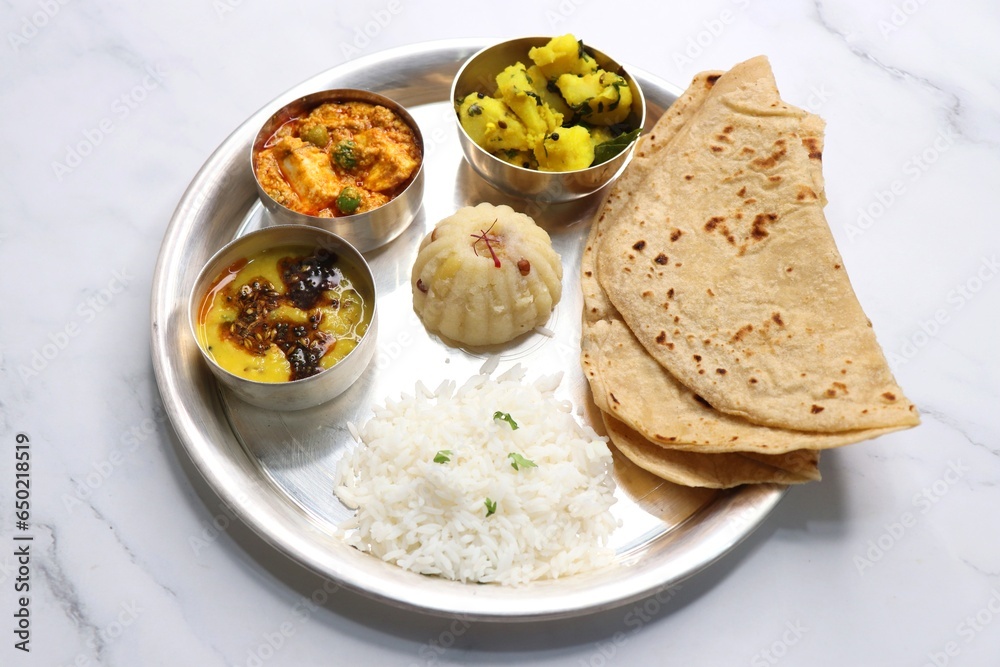 Indian vegetarian Thali or platter includes Aloo ki sabji, dal rice ...