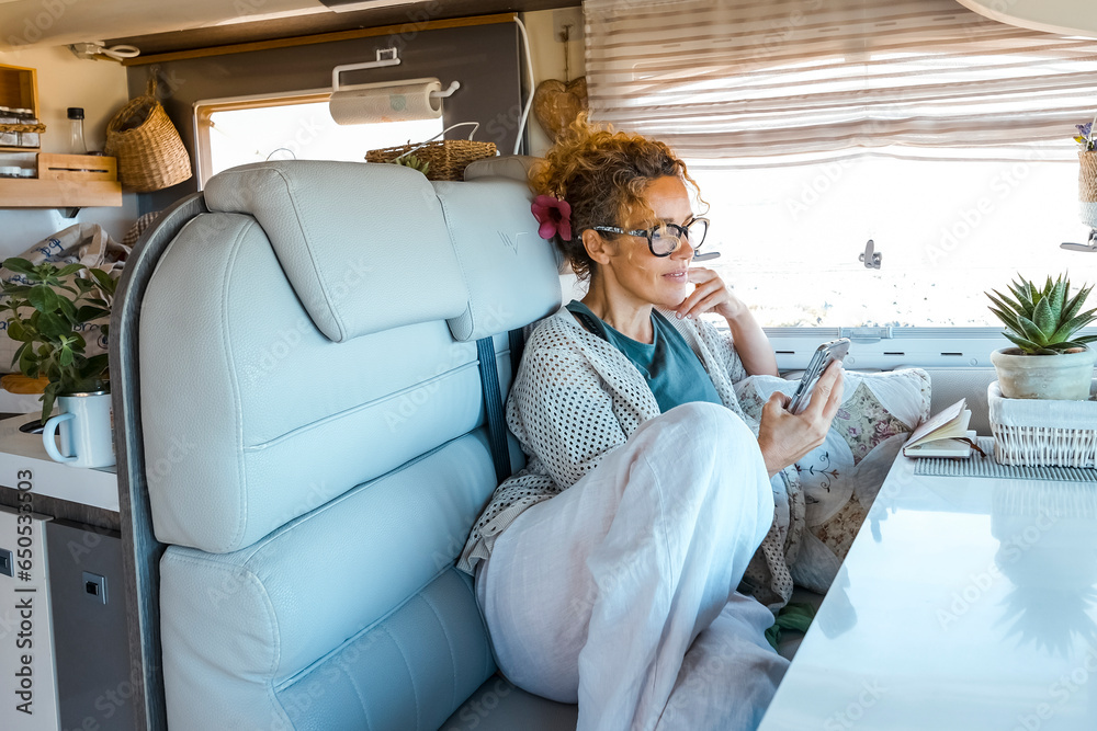 Adult woman relaxing inside a modern luxury camper van rv vehicle ...