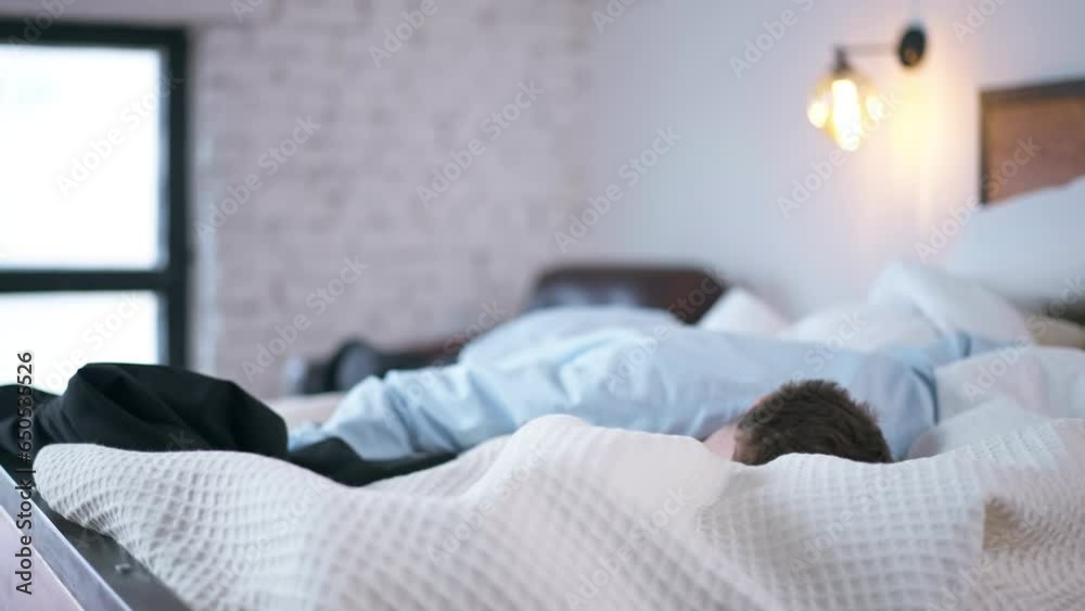 Live camera follows tired man falling forward on comfortable bed in ...