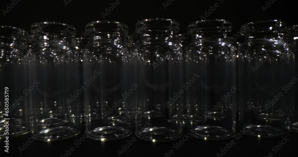 Empty glass vials in rows used for vaccine production and packaging on ...