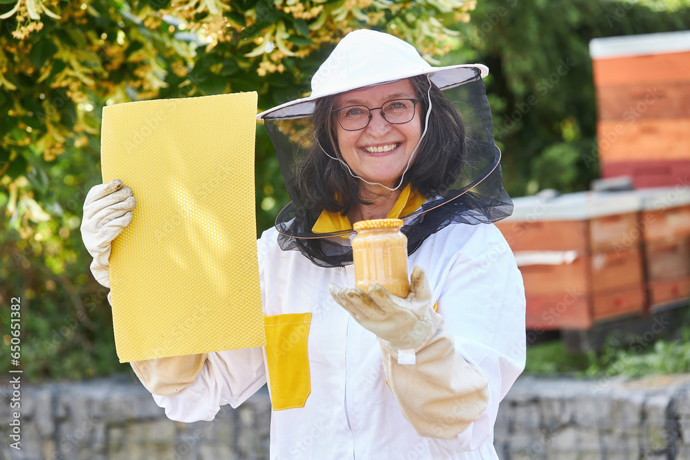 Female beekeeper offering bee honey and beeswax sheets Stock Photo ...