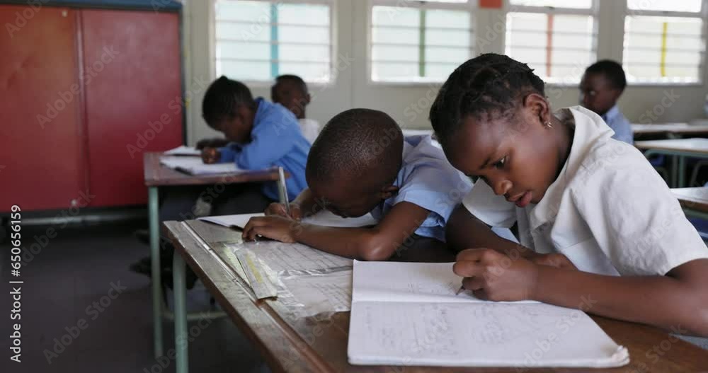 Close-up. Black African school children drawing at a desk in a ...