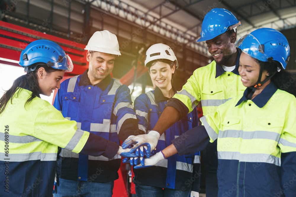 Foto de Group of male and female factory workers standing putting their ...