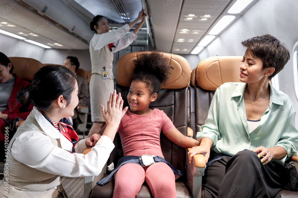 Foto de Friendly air hostess take care and help kid passenger on ...
