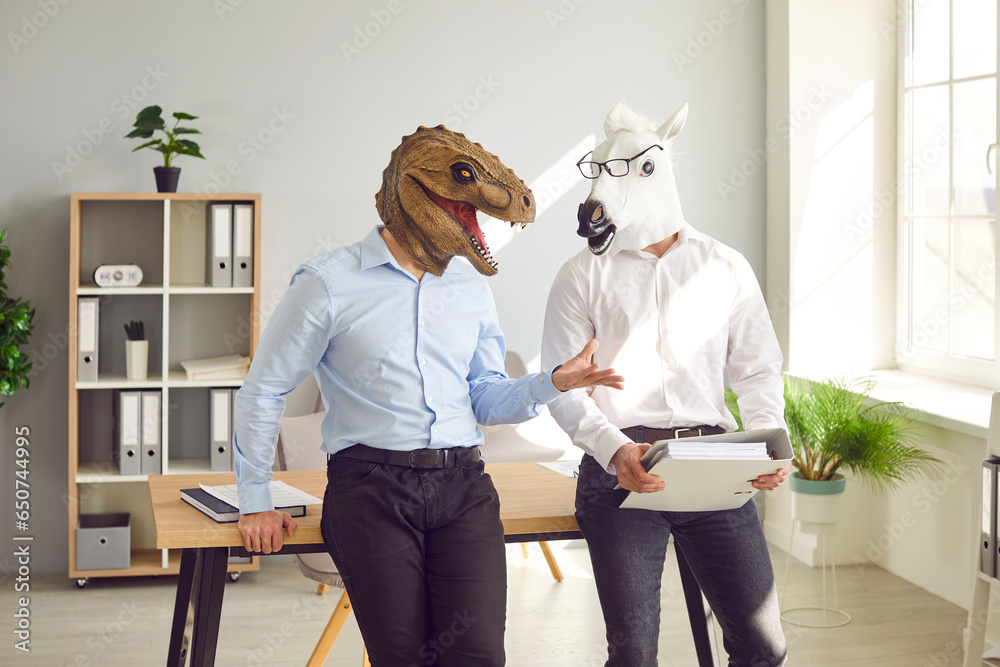 People at work in funny animal masks. Two young men in white shirts ...