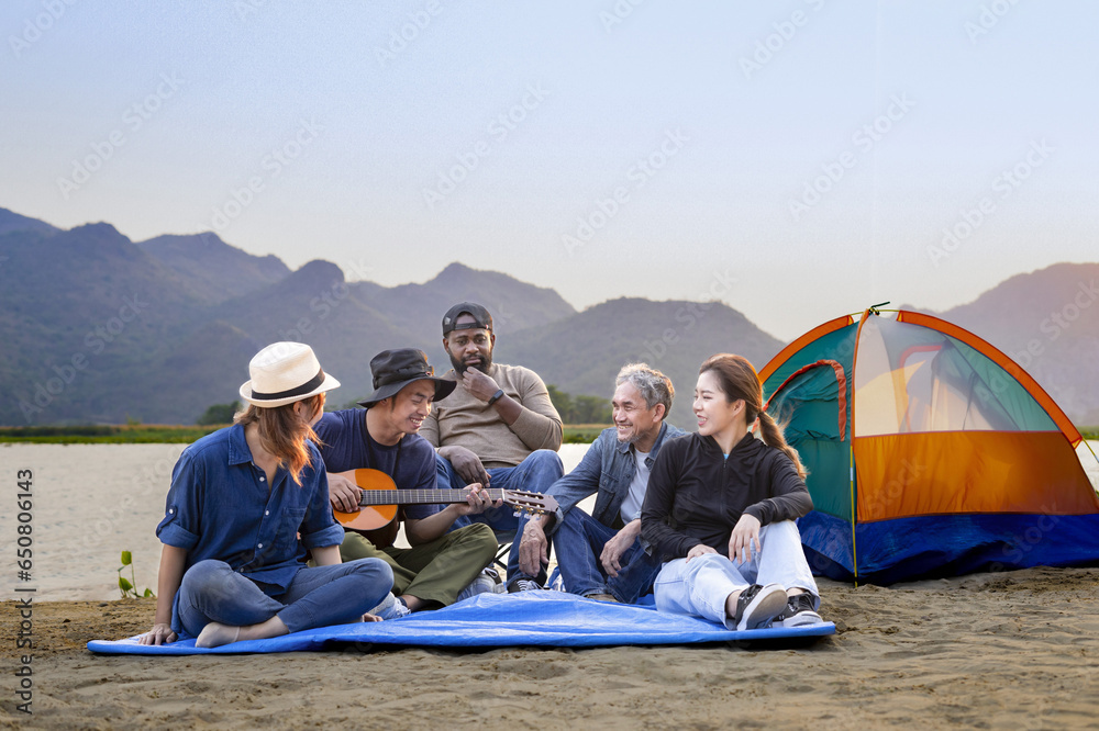 diverse group of friend having fun when they are camping by the pond ...