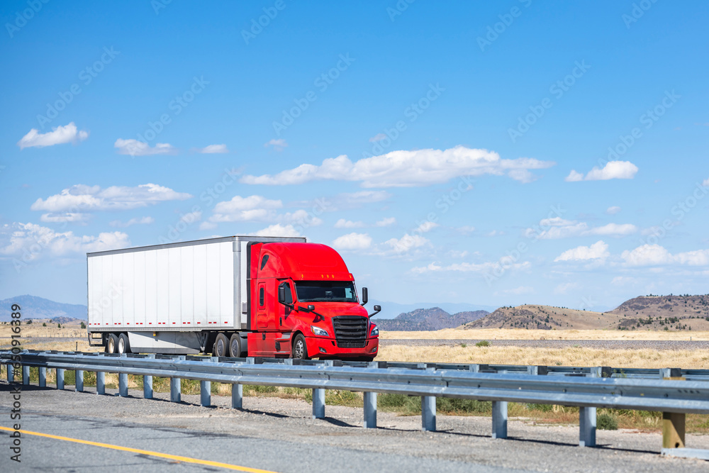 Professional carrier red big rig semi truck transporting cargo in dry ...