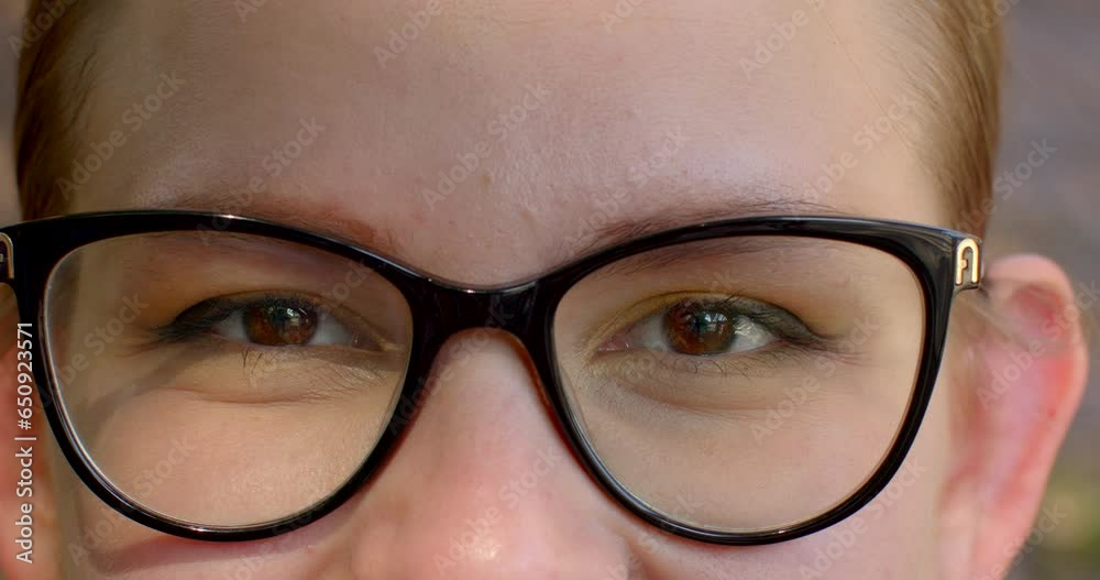 Close-up smiling woman eyes in glasses to correct or enhance vision ...