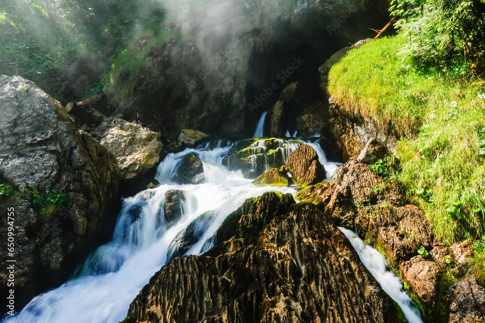 rushing clear cold water from a water source in a cave in salzburg ...
