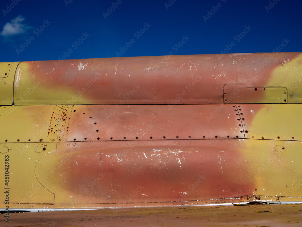 Side of a military jet war plane painted in military yellow and brown ...