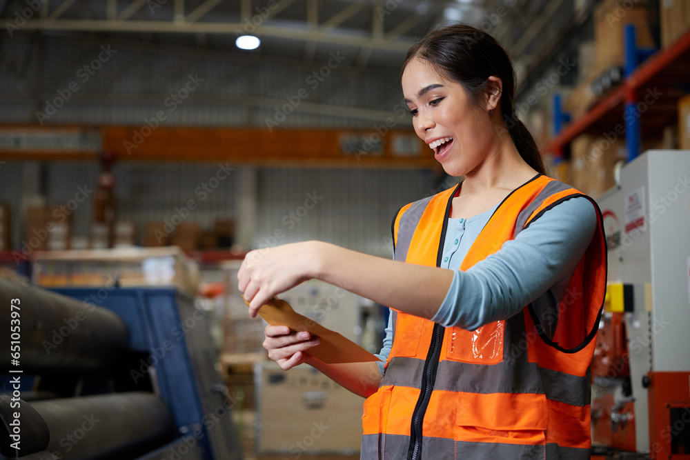 factory worker smiling and counting money from envelope in the ...