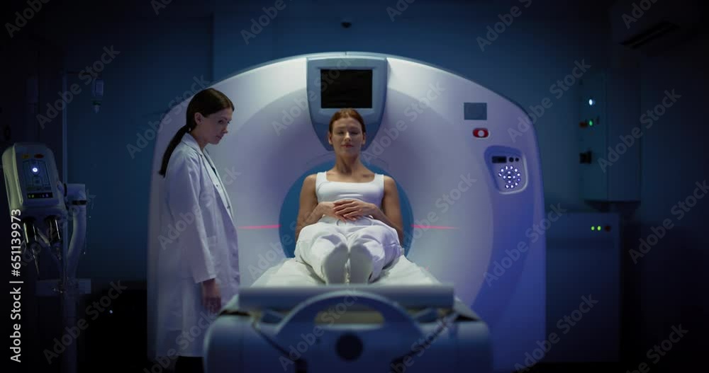 Medium Shot of a Female Patient Lying on a CT or MRI Scan Bed While it ...