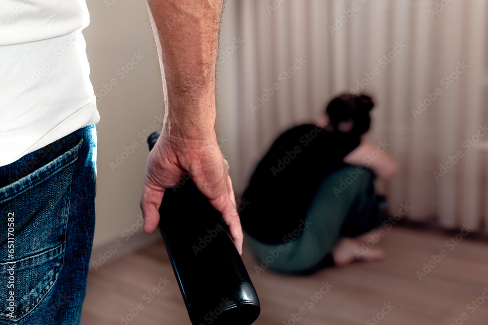 Man beating up his wife illustrating domestic violence. Woman is hiding ...
