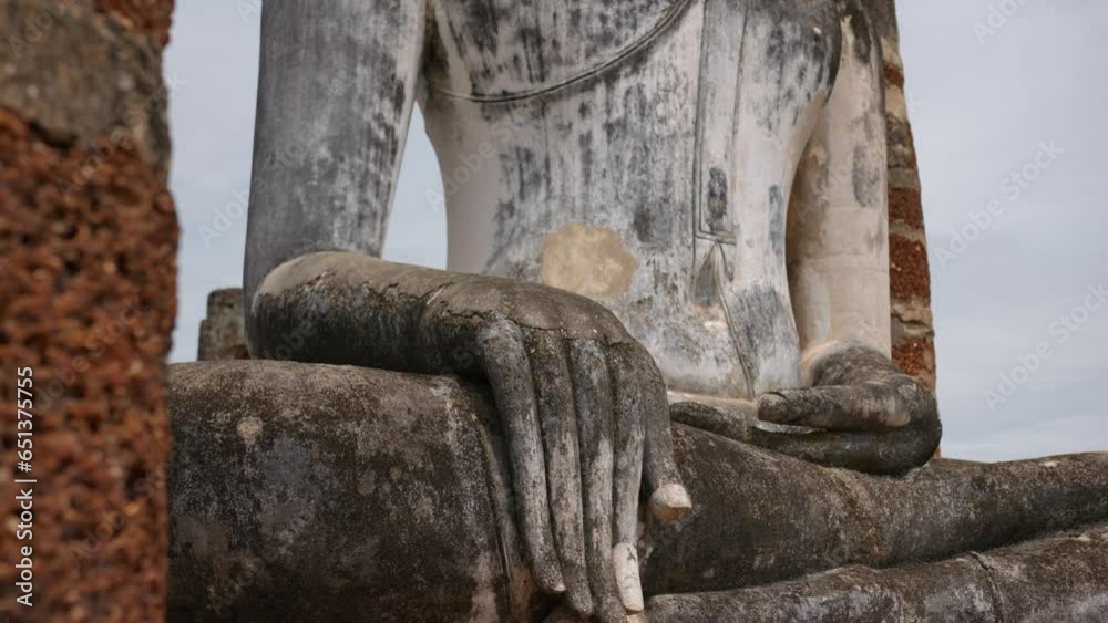 Rustic brick ruins and bottom half of sitting statue in ancient temple ...