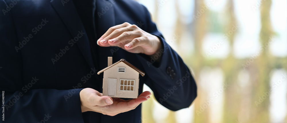 Man hands covering little house model from risk, disaster and problem ...