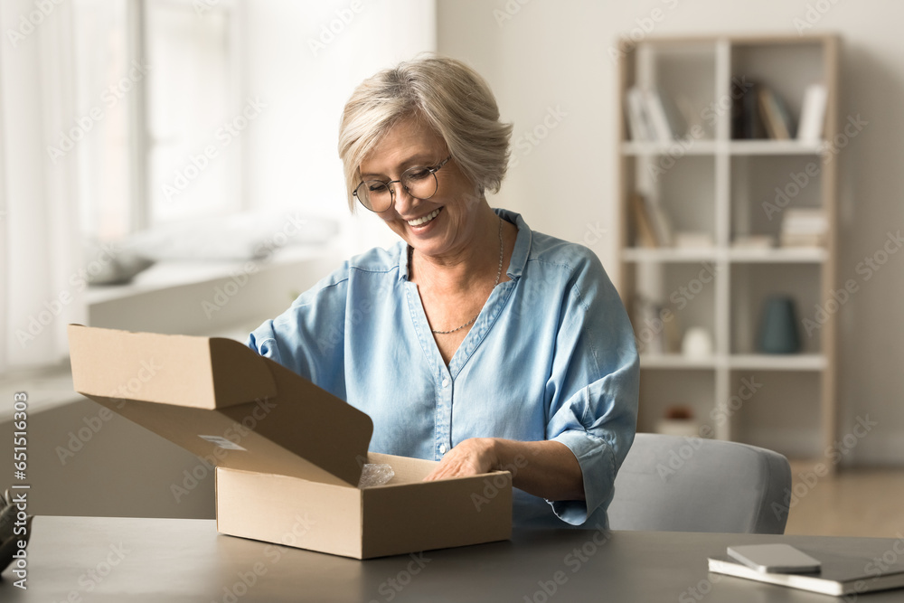 Positive satisfied customer woman receiving parcel, unpacking paper ...