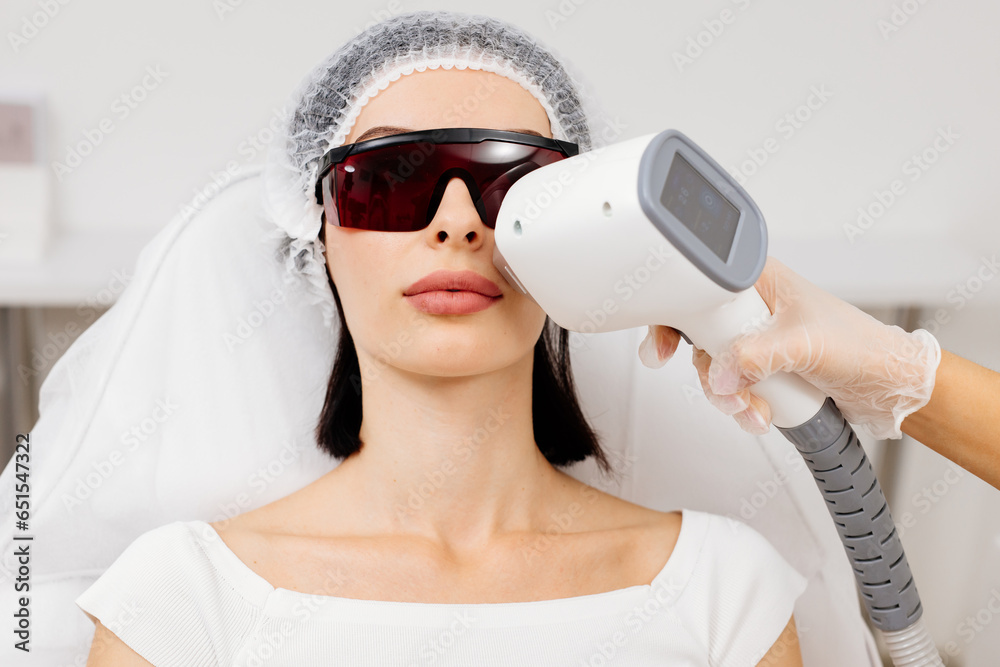 Laser hair removal face of a beautiful woman in a beauty salon. Laser ...