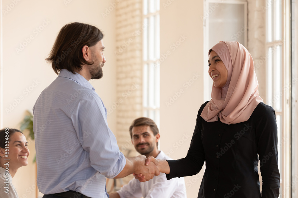 Middle eastern ethnicity Arabian female in hijab worker shake hands ...