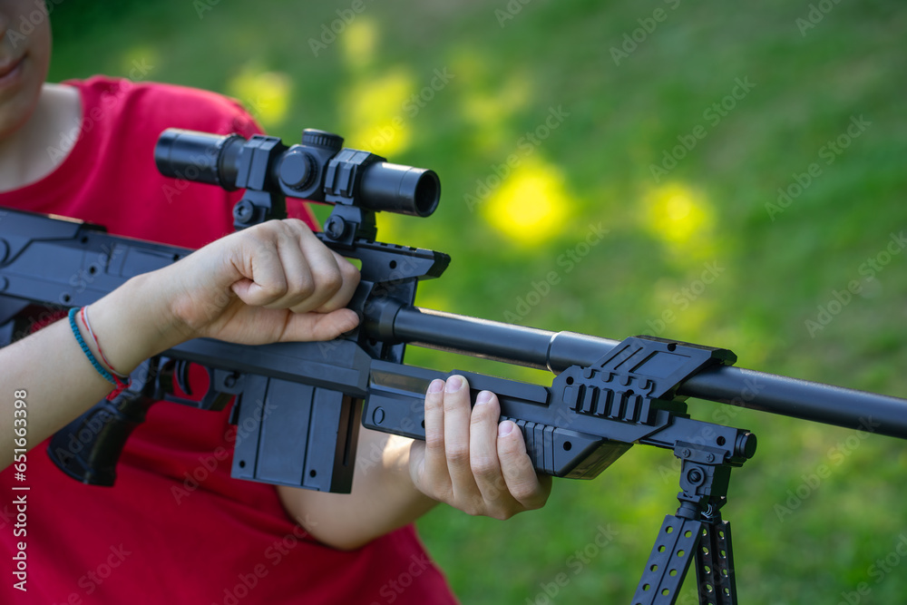 A child loads a plastic rifle.Shooting lessons for children. Load a ...