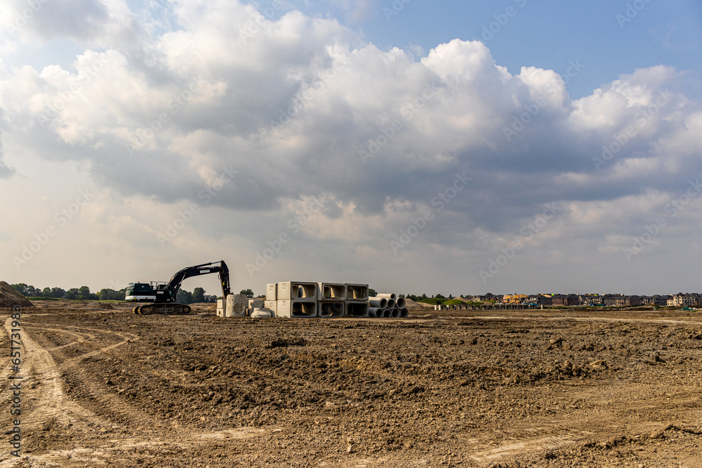 Construction site with large excavator digging and a partially ...