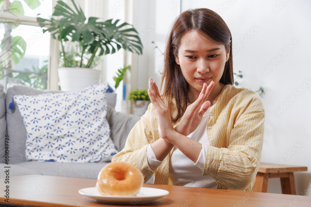Asian female refusing the donut plate that is a mixture of trans fat ...