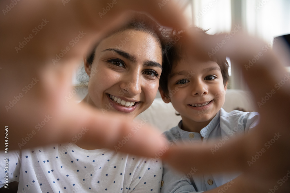 Smiling Indian mother and 5s son showing looking through heart shape ...