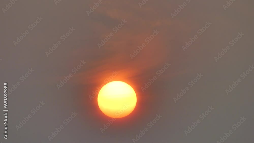 Grey sky with yellow, orange and red solar disk with Atmospheric ...
