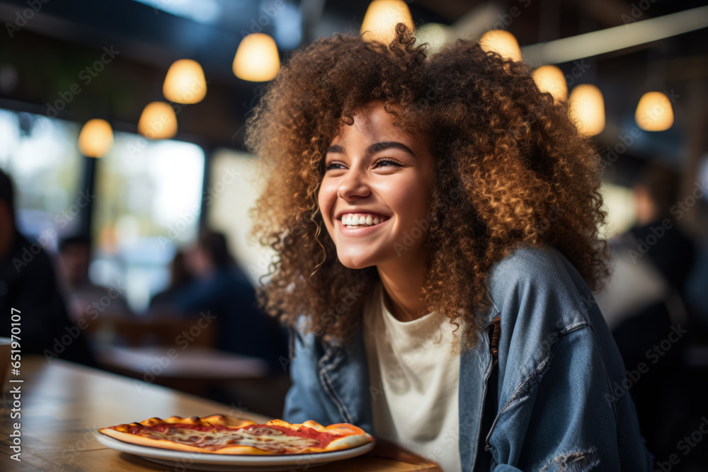 College student enjoying pizza slice during vivacious campus cafe study ...