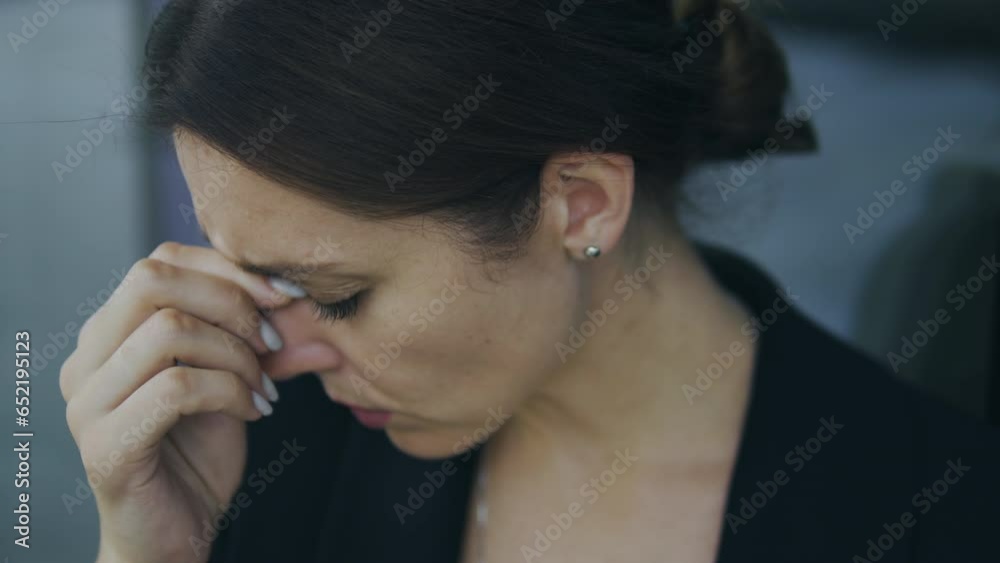 Deeply upset unhealthy woman massaging her bridge of the nose and ...