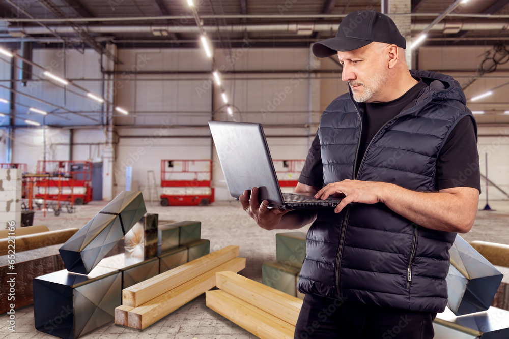 Man installer near building materials. Disassembled ventilation system ...