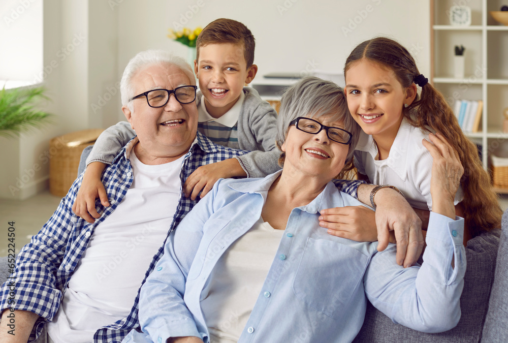 Family portrait of happy grandparents and children on sofa at home ...