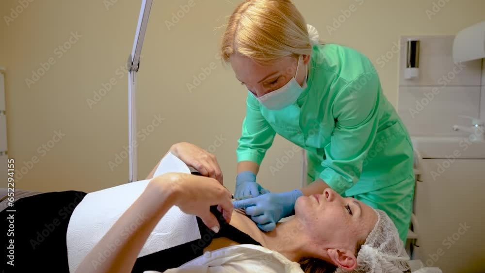 Woman having an injection on bust skin in beauty salon for breast ...