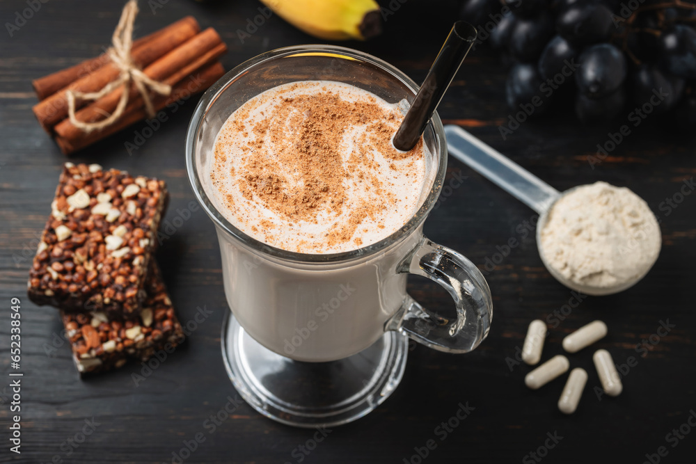 Glass of protein milkshake drink with straw and scoop of whey protein ...