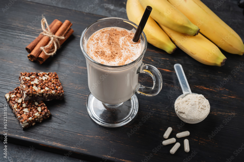 Glass of protein milkshake drink with straw and scoop of whey protein ...