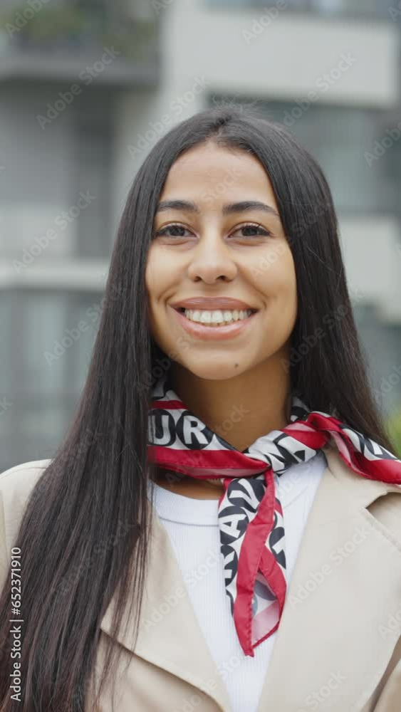 Vertical Screen: Young amiable black woman with long hair wearing coat ...