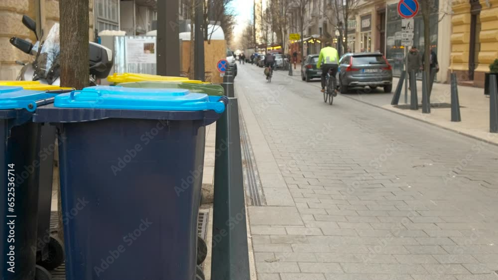 Garbage bins in public street with citizens. A view of garbage bins in ...