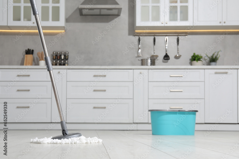 Mop and bucket on white parquet in kitchen. Cleaning floor Stock Photo ...