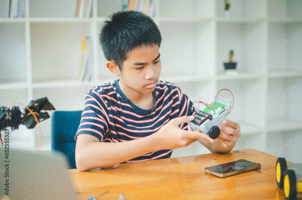 Asian boy learning and studying the work of technology robots ...