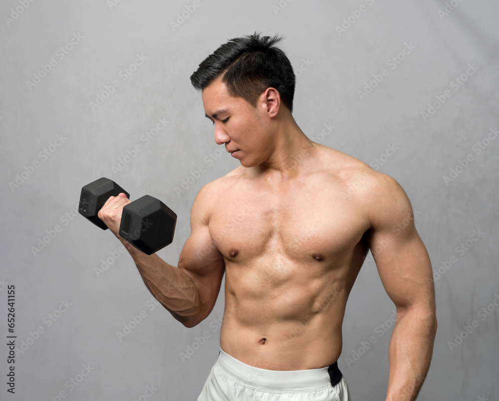 A physically fit man engaged in a workout session at a modern gym ...