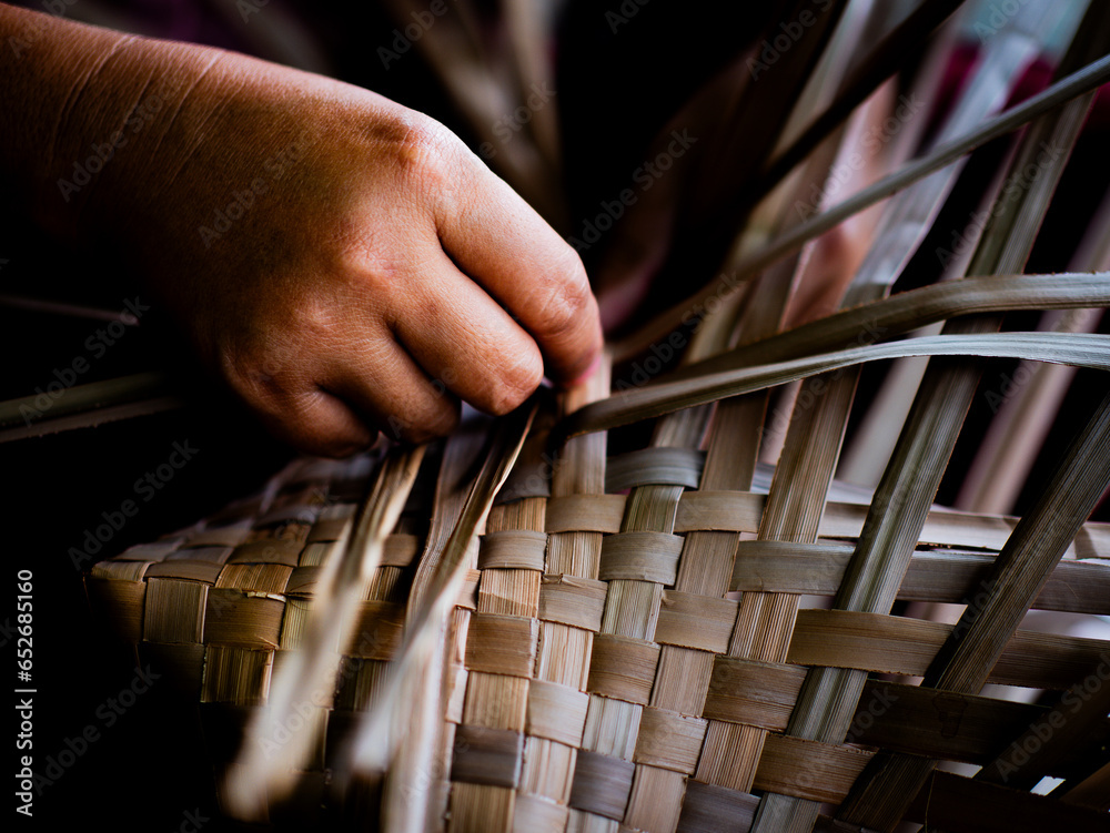 Selective focus woman´s hand weaving a basket case from mangrove palm ...