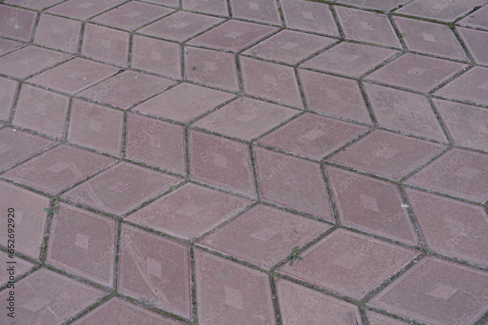 Dusty surface of grayish pink diamond shaped concrete pavement with ...