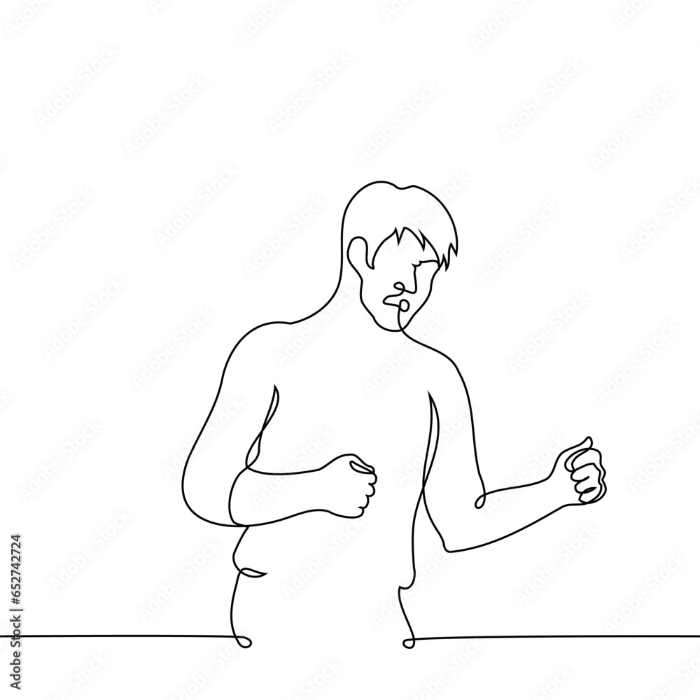 man stands with clenched fists and a grimace of rage or irritation on ...