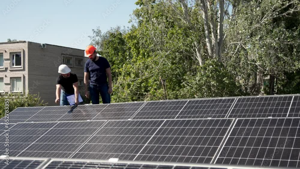Installation, Connection and mounting of solar panels. Two workers ...