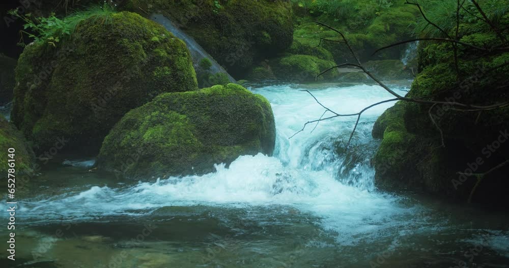 Steam rises from the surface of a fast-flowing river in a mountain ...