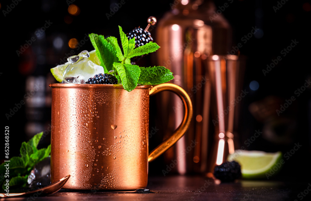 Moscow mule cocktail drink with blackberry in copper mug with lime, ice ...